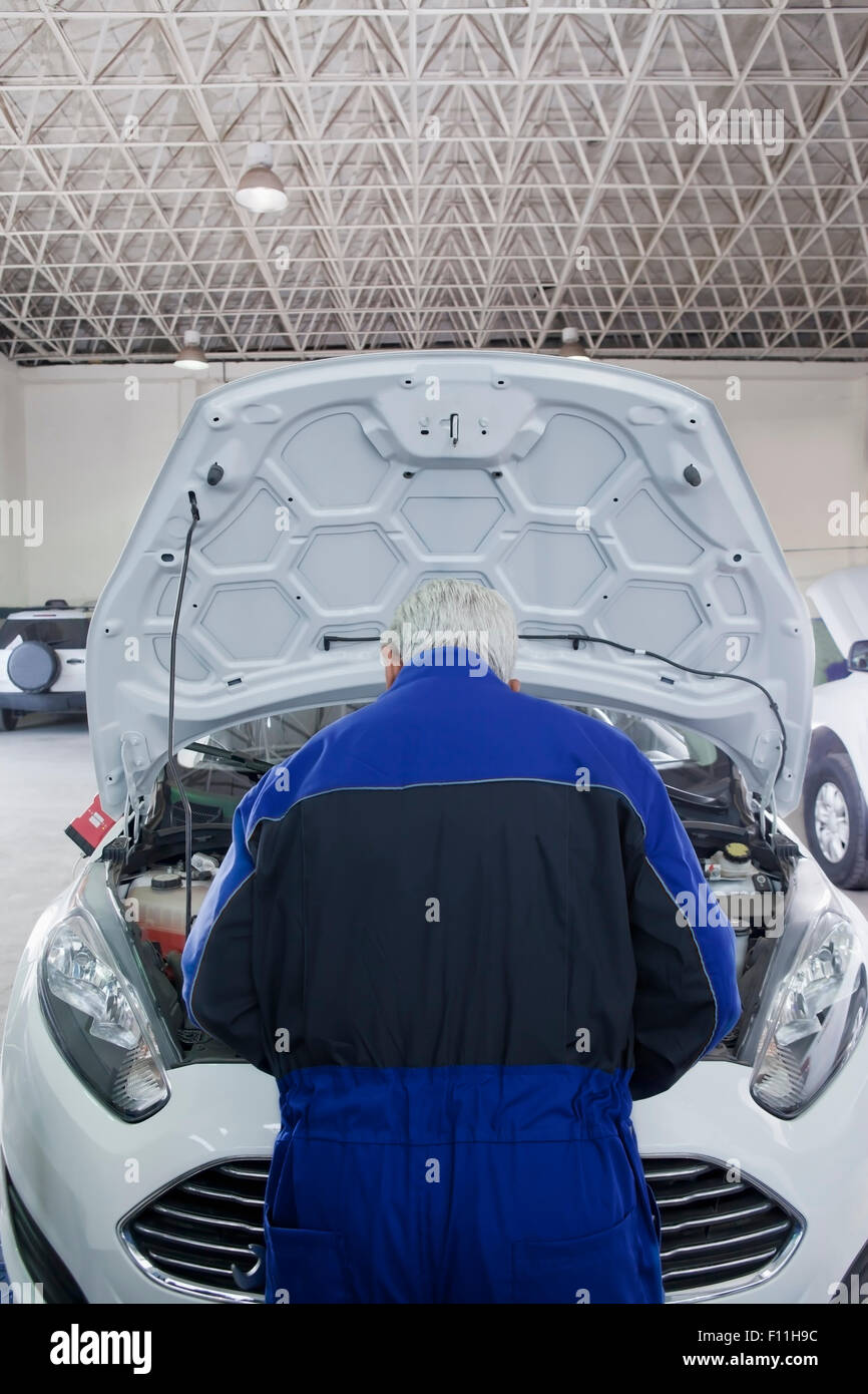 Older Hispanic mechanic repairing car in garage Stock Photo - Alamy