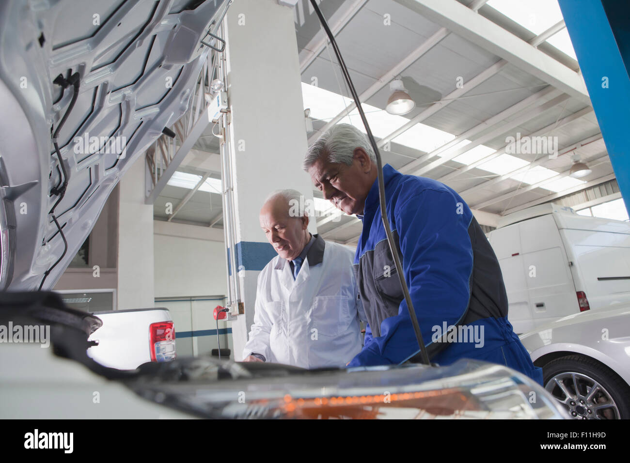 Older Hispanic mechanics repairing car in garage Stock Photo - Alamy