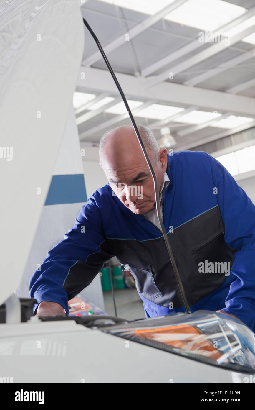 Older Hispanic mechanic repairing car in garage Stock Photo - Alamy