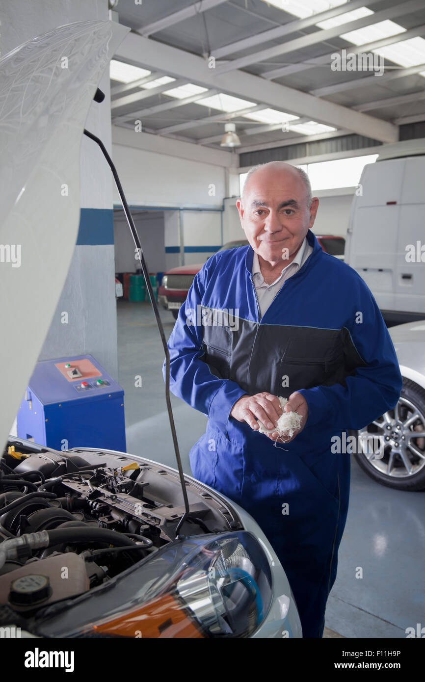 Older Hispanic mechanic working on car in garage Stock Photo - Alamy