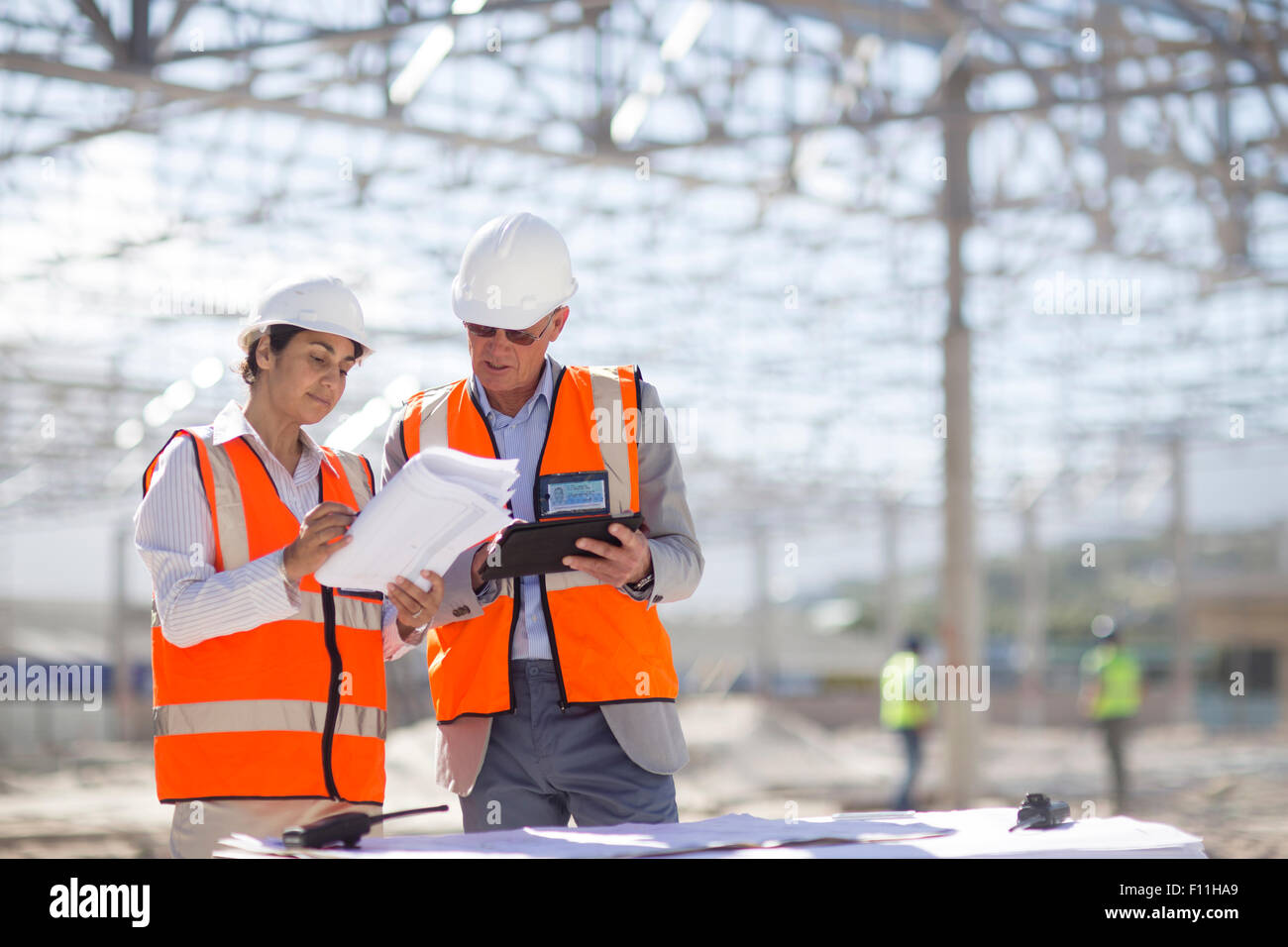Architects reading blueprints at construction site Stock Photo - Alamy