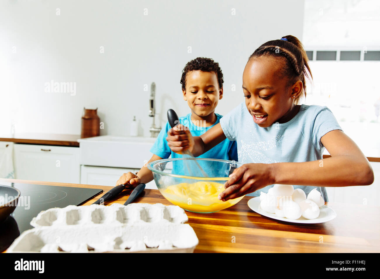 Brother and sister cooking breakfast in kitchen Stock Photo - Alamy