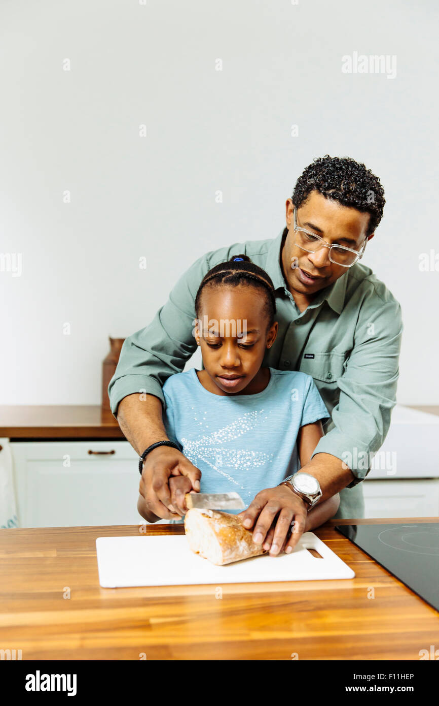 Father teaching daughter to slice bread in kitchen Stock Photo - Alamy