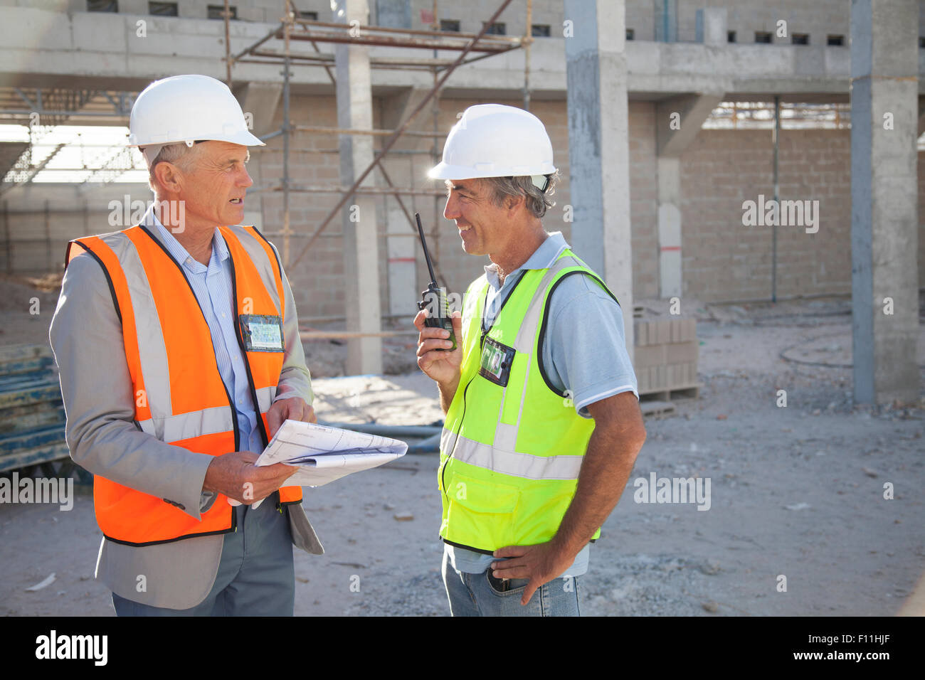 Caucasian architect and construction worker talking at construction ...