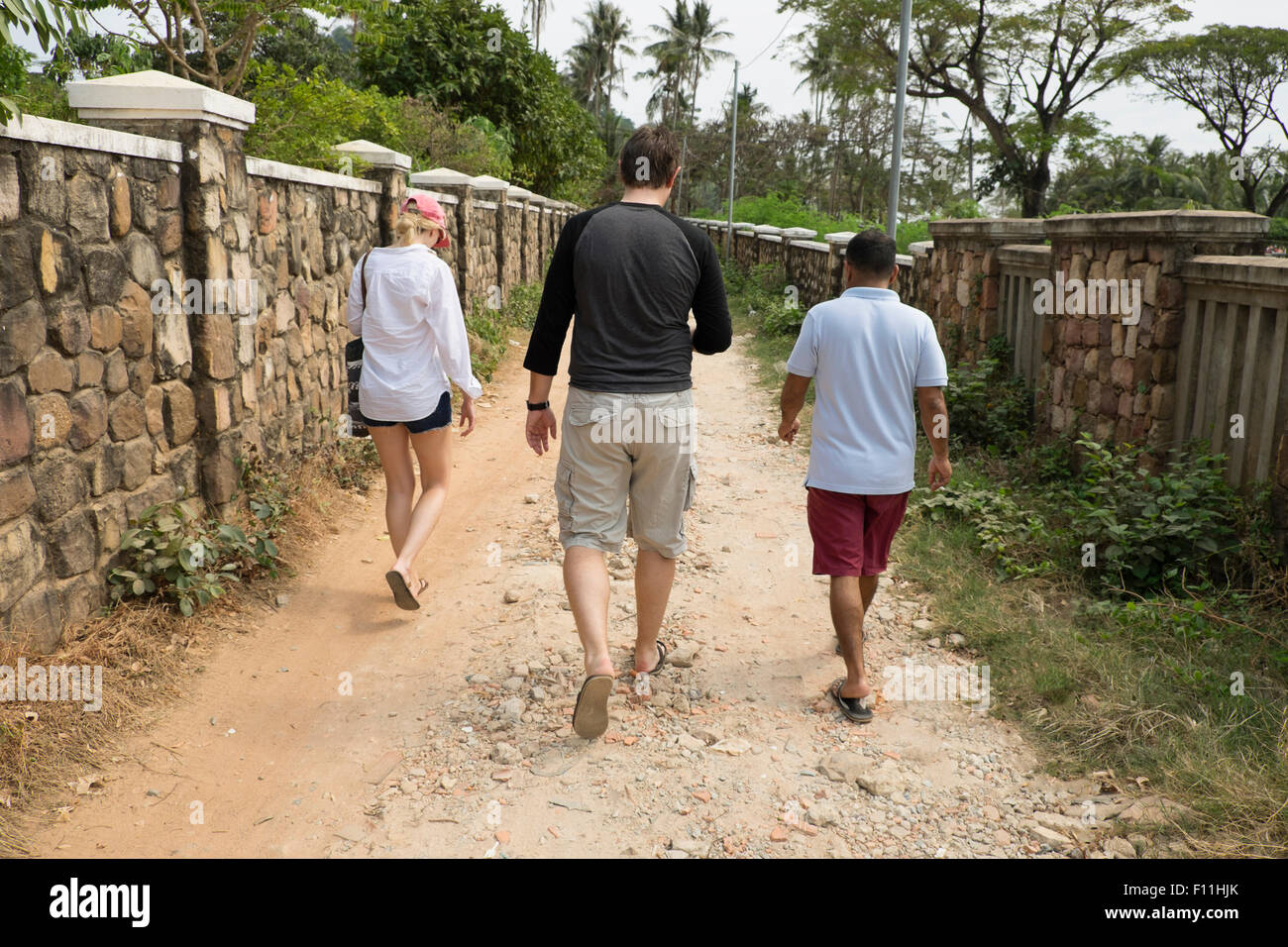 Rear view of friends walking on dirt path Stock Photo - Alamy
