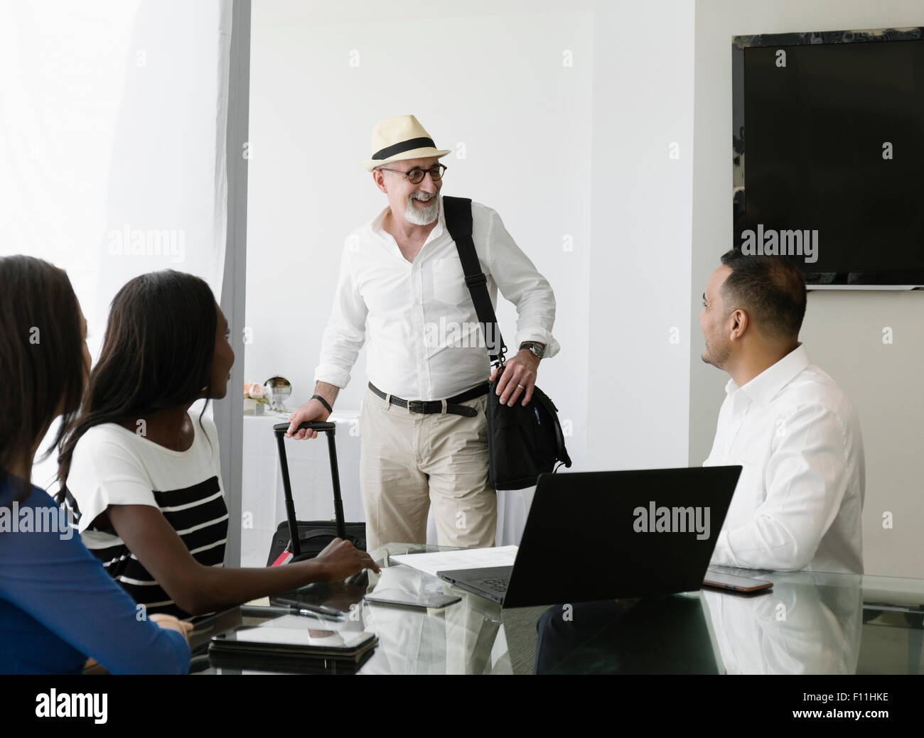 Businessman greeting colleagues in office meeting Stock Photo - Alamy