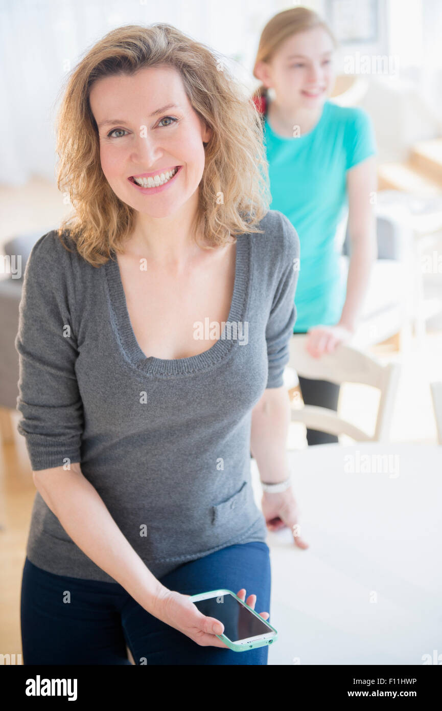 Caucasian woman holding cell phone in dining room Stock Photo - Alamy