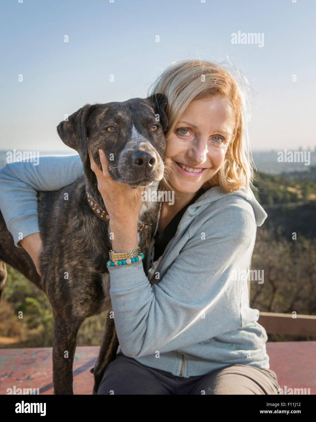 Caucasian woman hugging dog on hilltop Stock Photo - Alamy