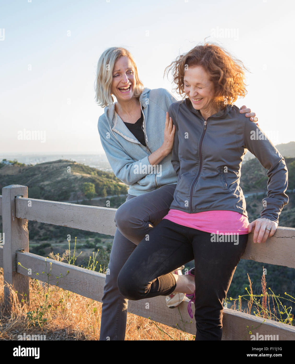 Woman sitting on fence hi-res stock photography and images - Alamy
