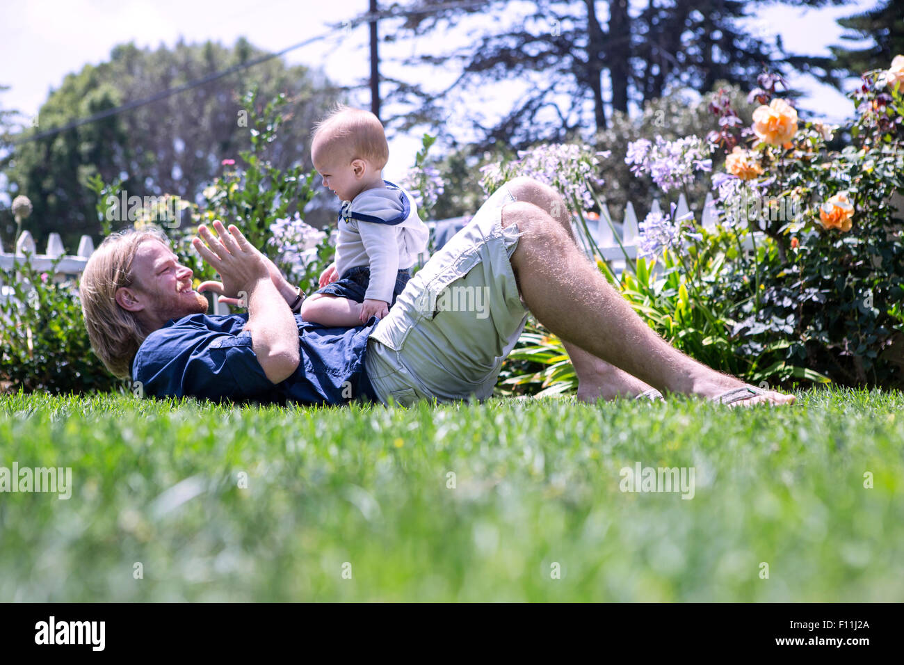 Caucasian father and son playing in grass Stock Photo - Alamy