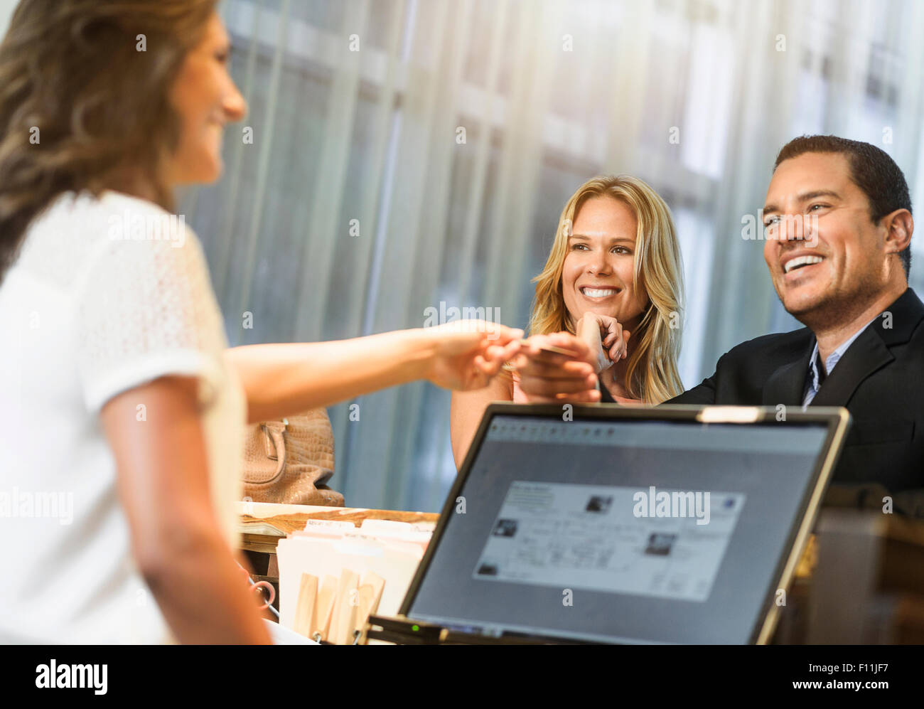Couple checking in to hotel with concierge Stock Photo - Alamy