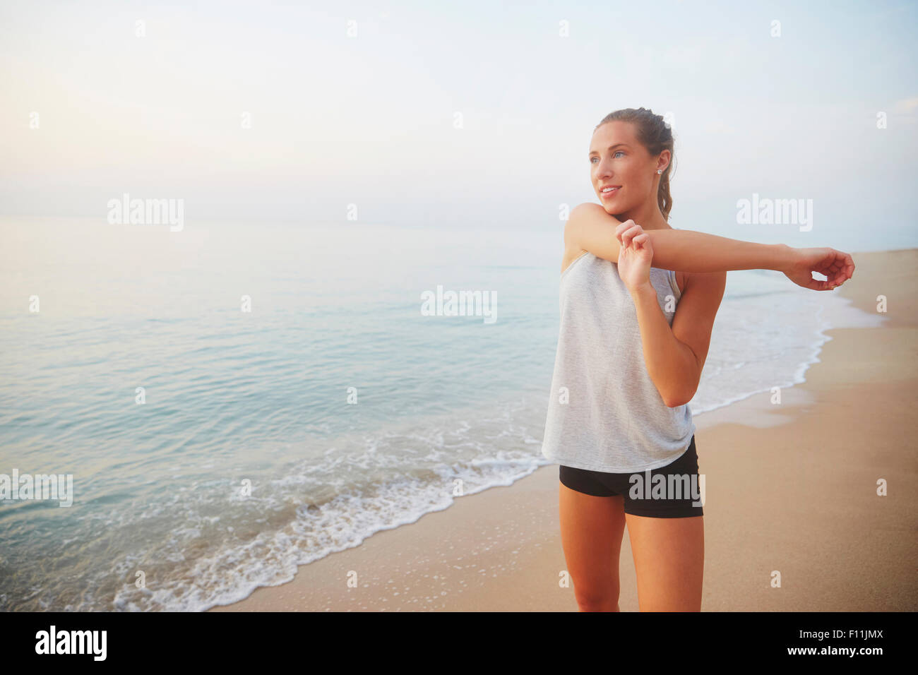Athlete stretching on beach Stock Photo - Alamy
