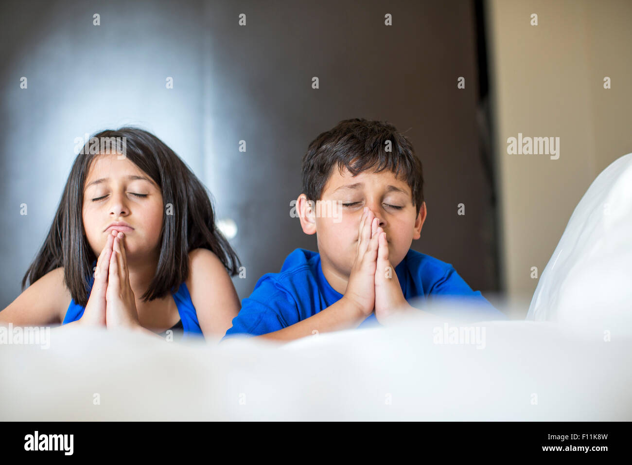 Close up of concerned Hispanic children praying Stock Photo - Alamy