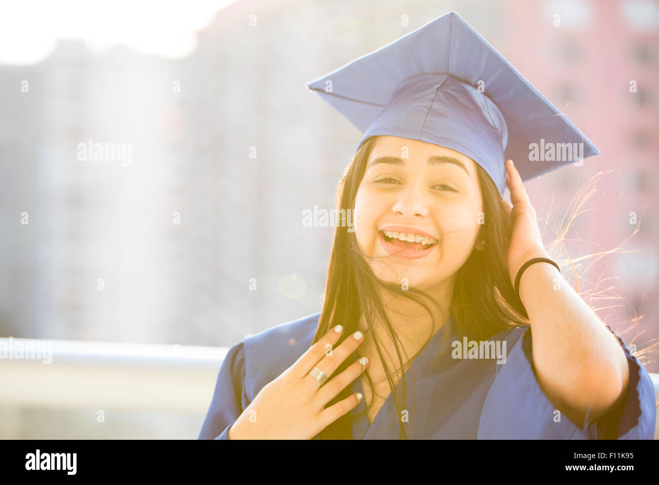 Smiling Hispanic girl wearing graduation robe and mortarboard Stock ...