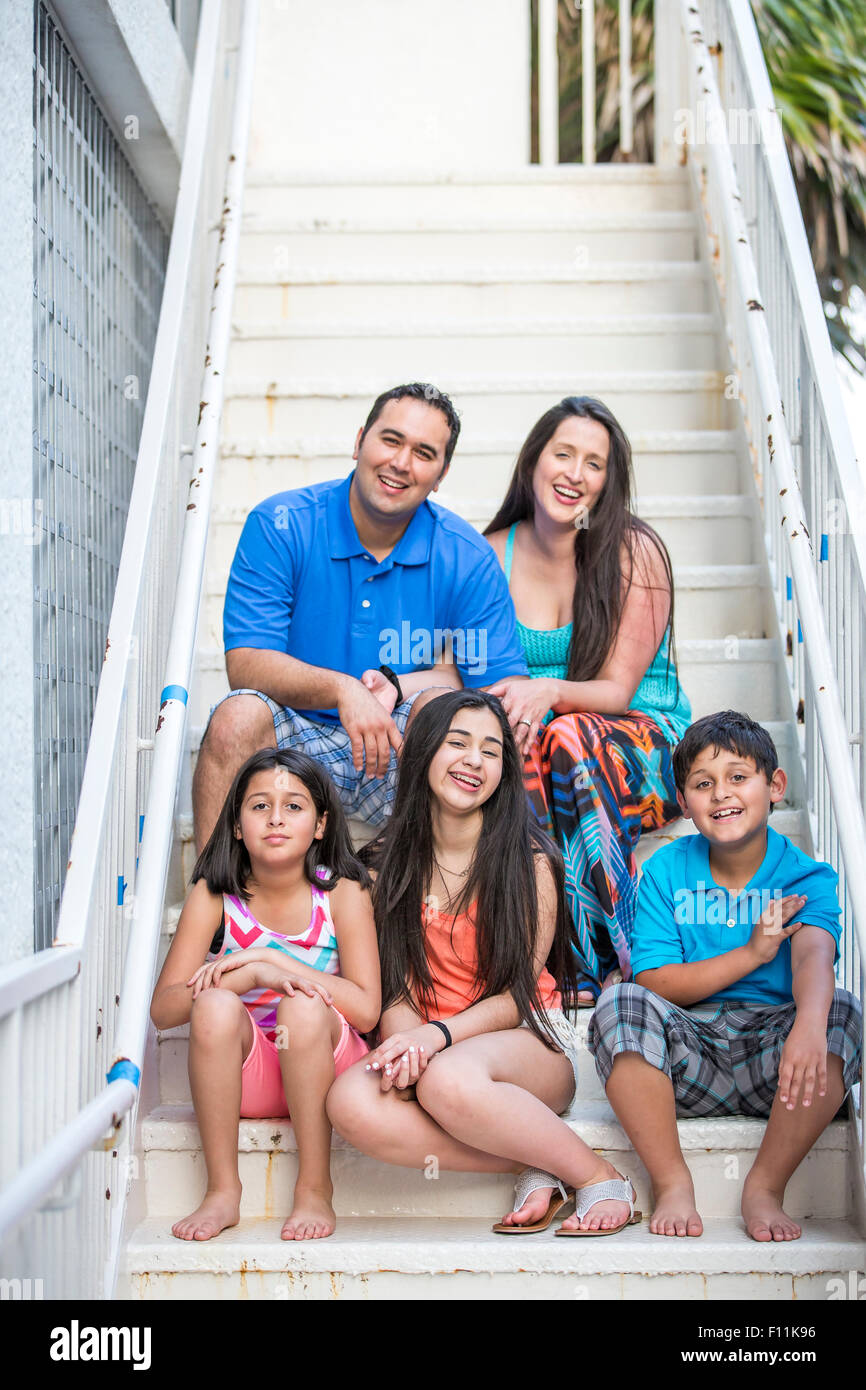 Hispanic family smiling on staircase Stock Photo - Alamy