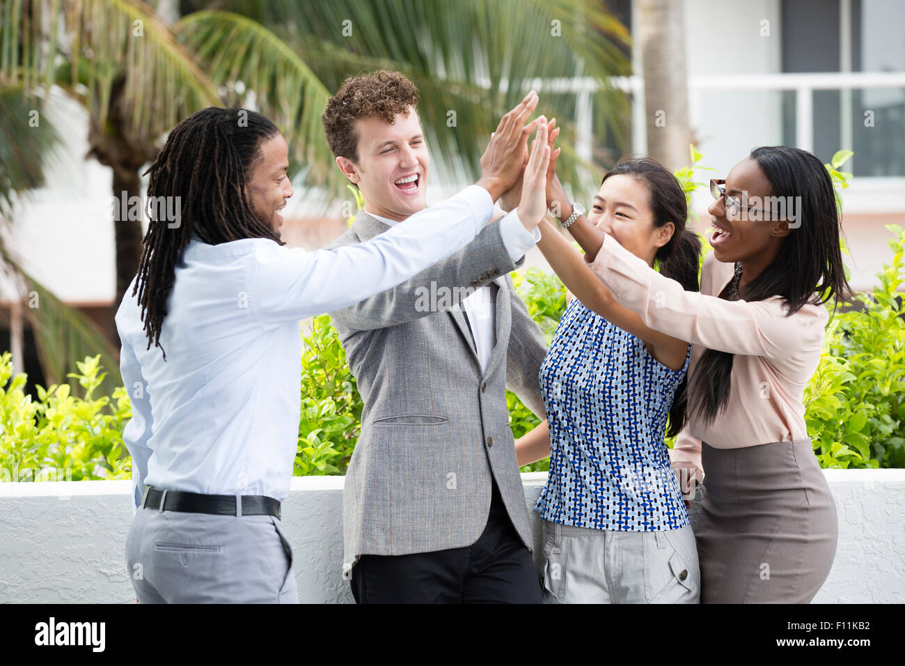 Business people high-fiving outdoors Stock Photo - Alamy