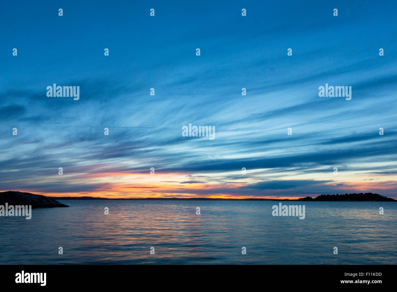 Clouds in sunset sky over still ocean Stock Photo - Alamy