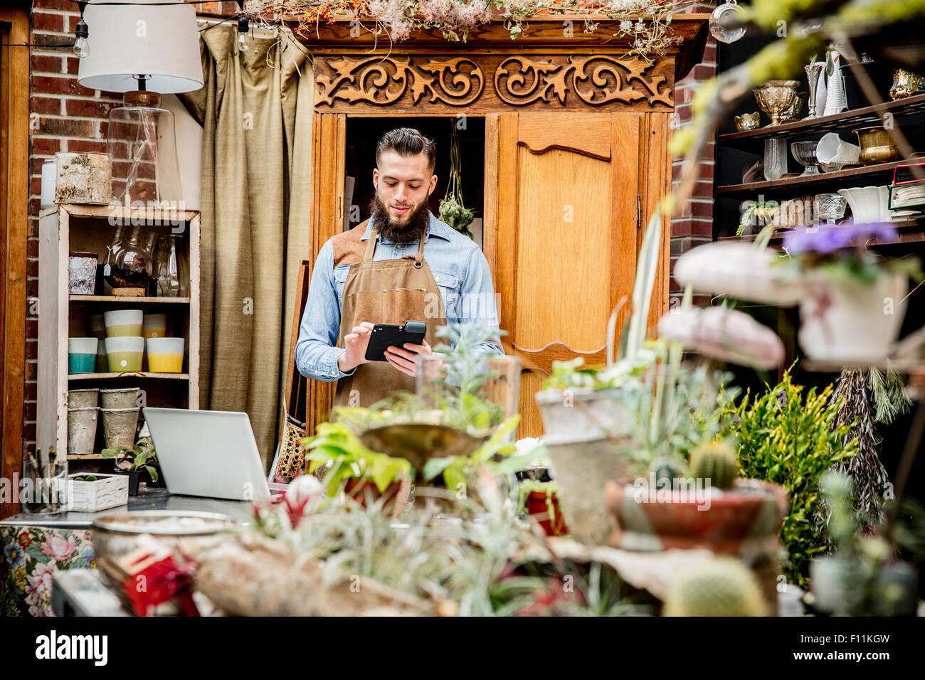Caucasian employee using digital tablet in plant nursery Stock Photo ...