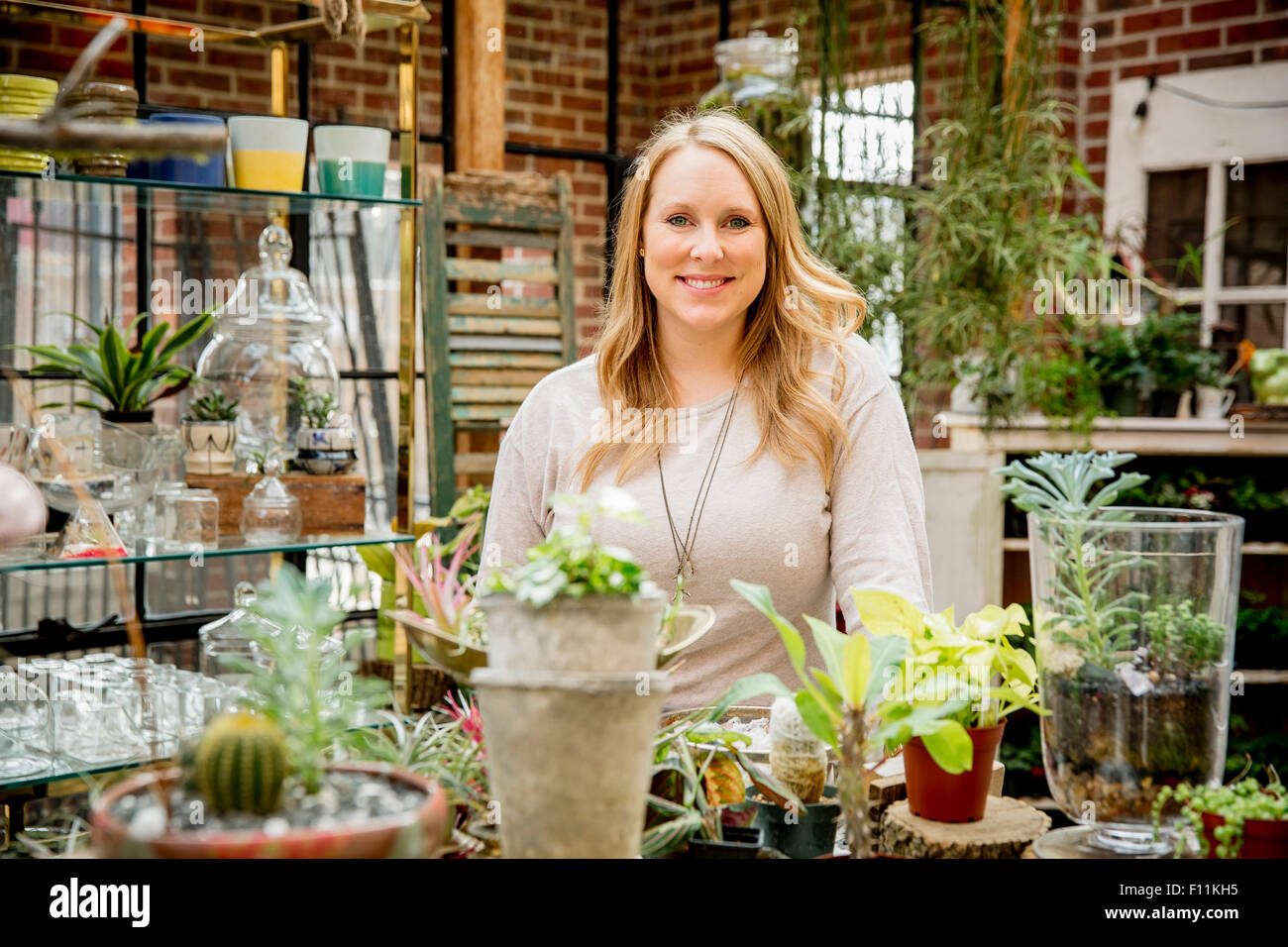 Caucasian employee smiling in plant nursery Stock Photo - Alamy