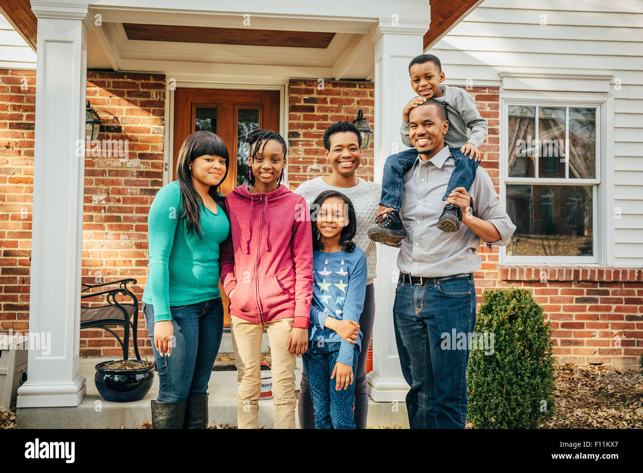 Black family smiling outside house Stock Photo - Alamy