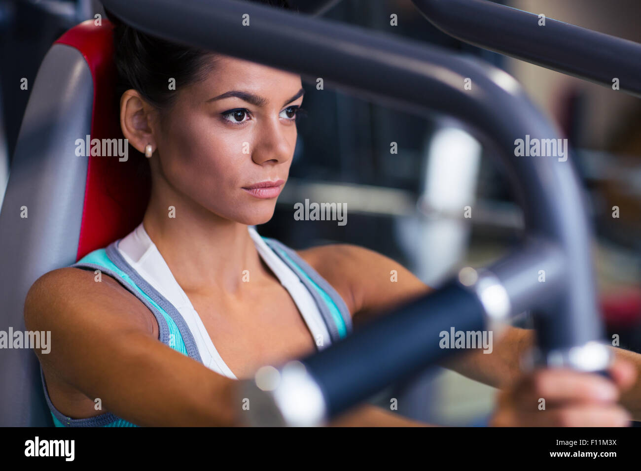 Portrait of attractive woman workout on exercises machine at fitness ...