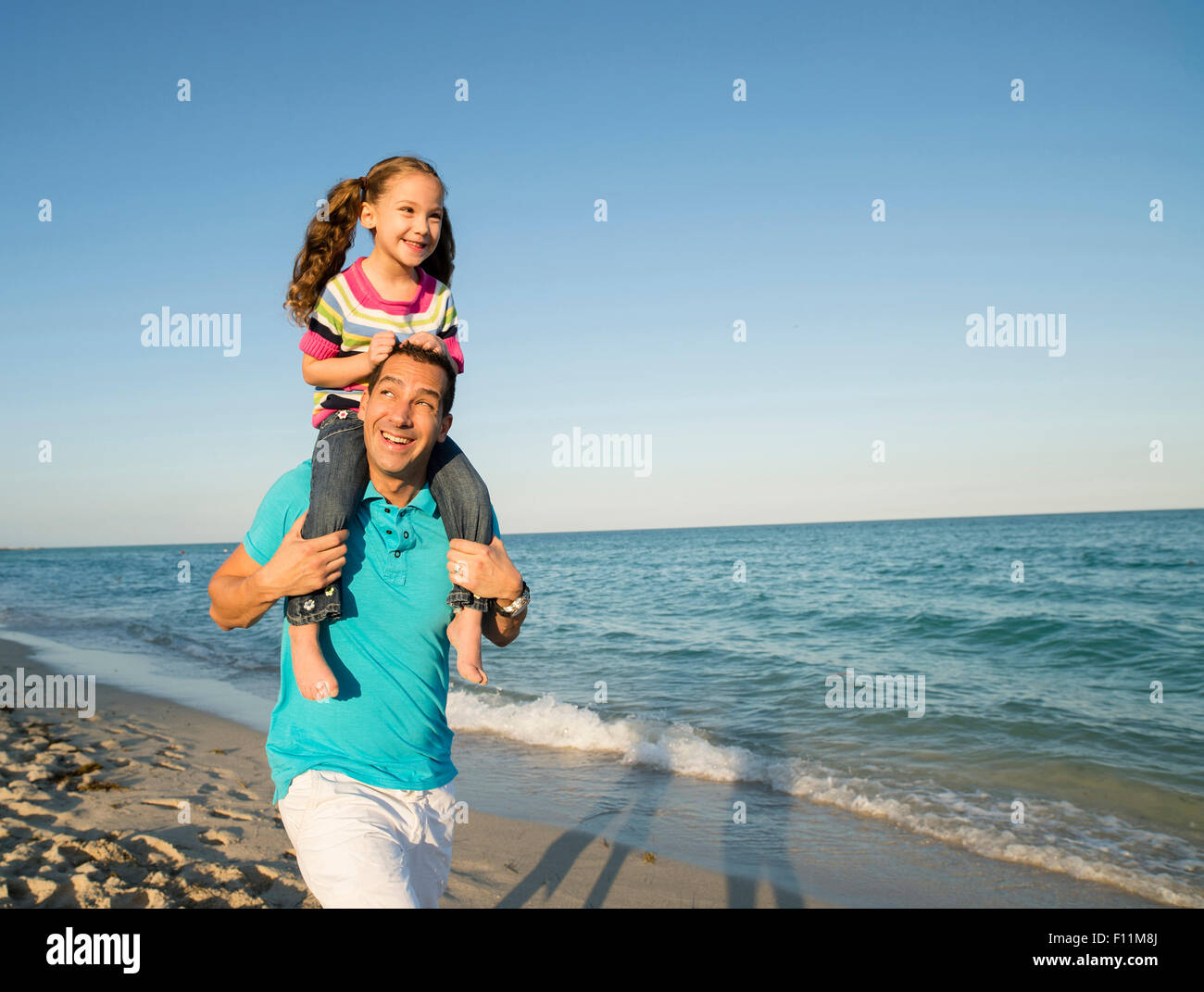 Father carrying daughter on the beach hi-res stock photography and images - Alamy