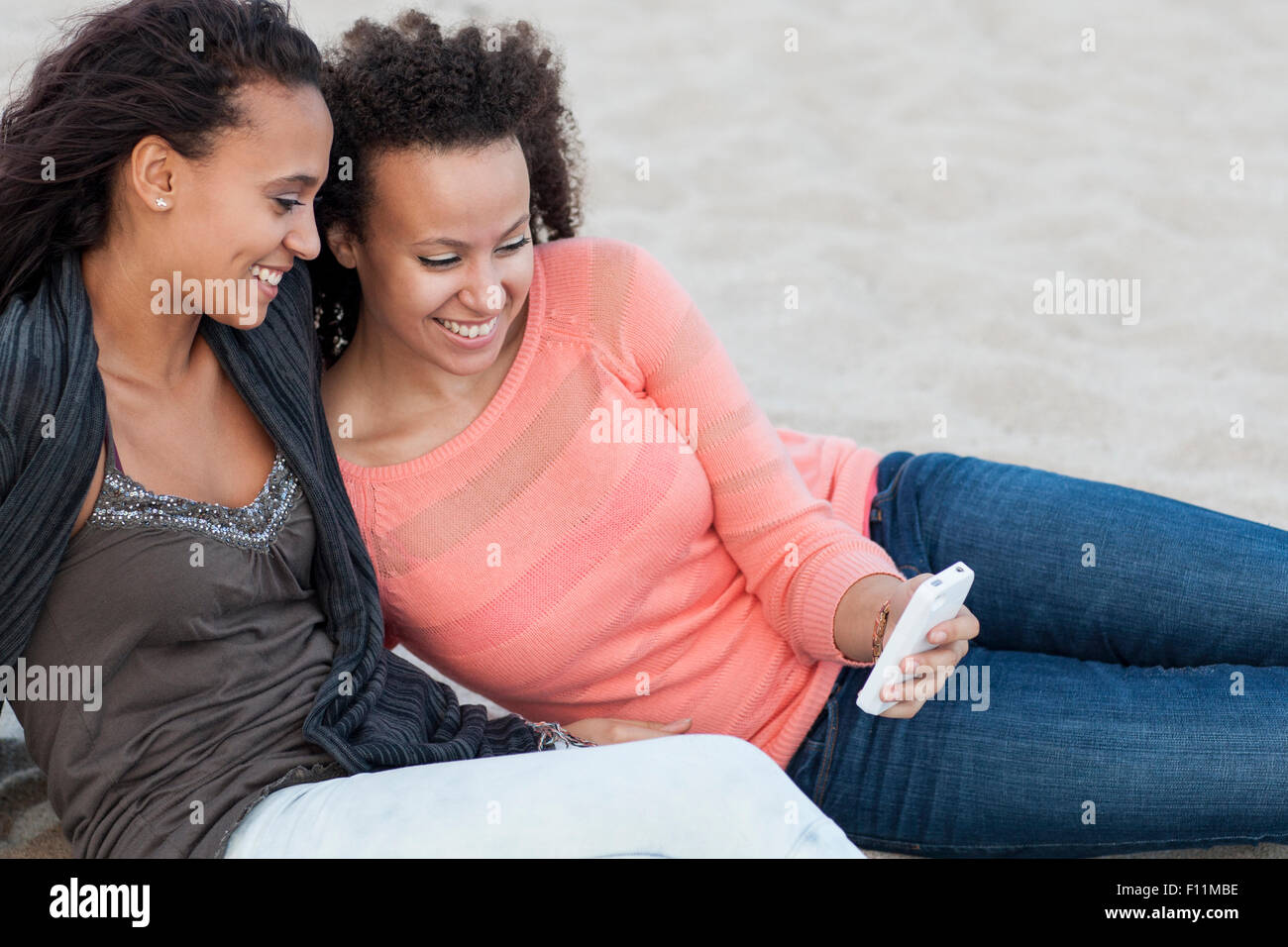 Woman looking at mobile phone on beach hi-res stock photography and ...