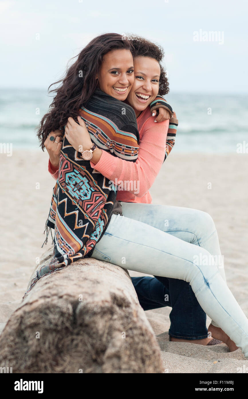 Smiling women hugging on beach Stock Photo - Alamy