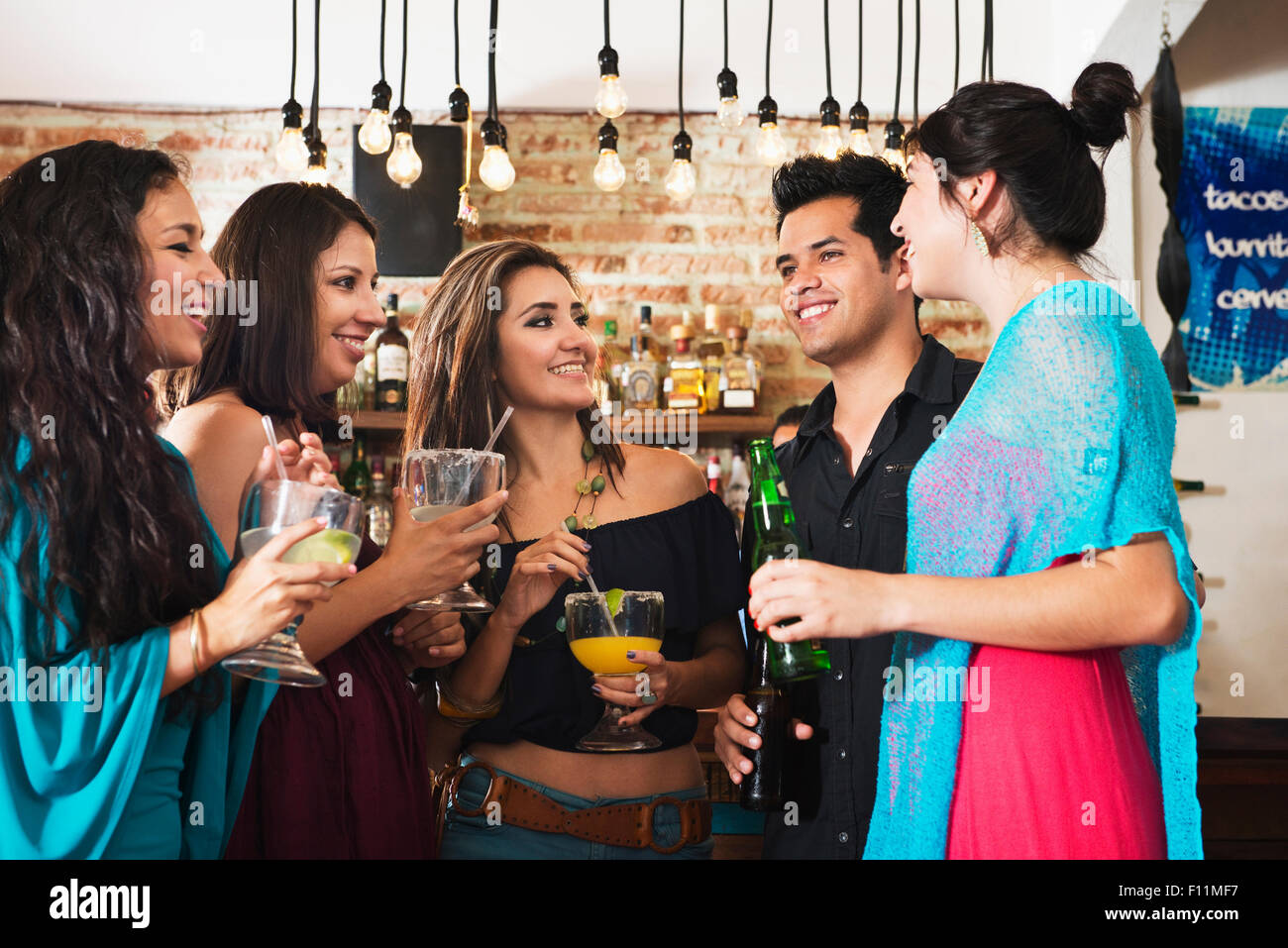Hispanic friends having drink in bar Stock Photo - Alamy