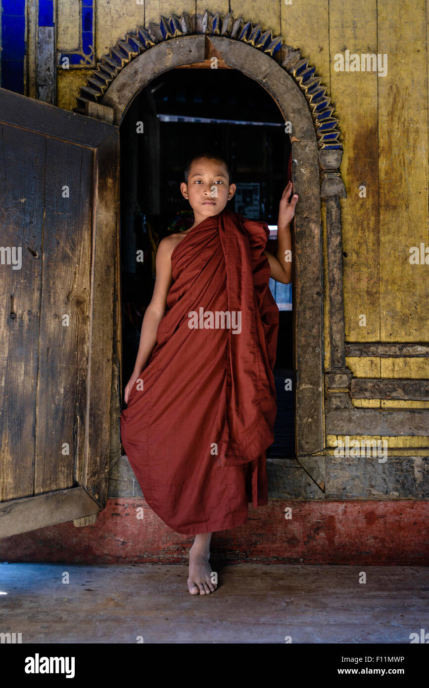 Asian monk-in-training walking out of temple archway Stock Photo - Alamy