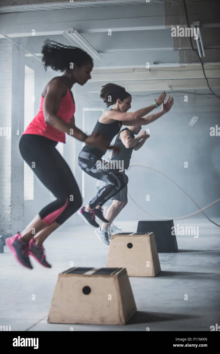 Athletes jumping on platforms in gym Stock Photo - Alamy