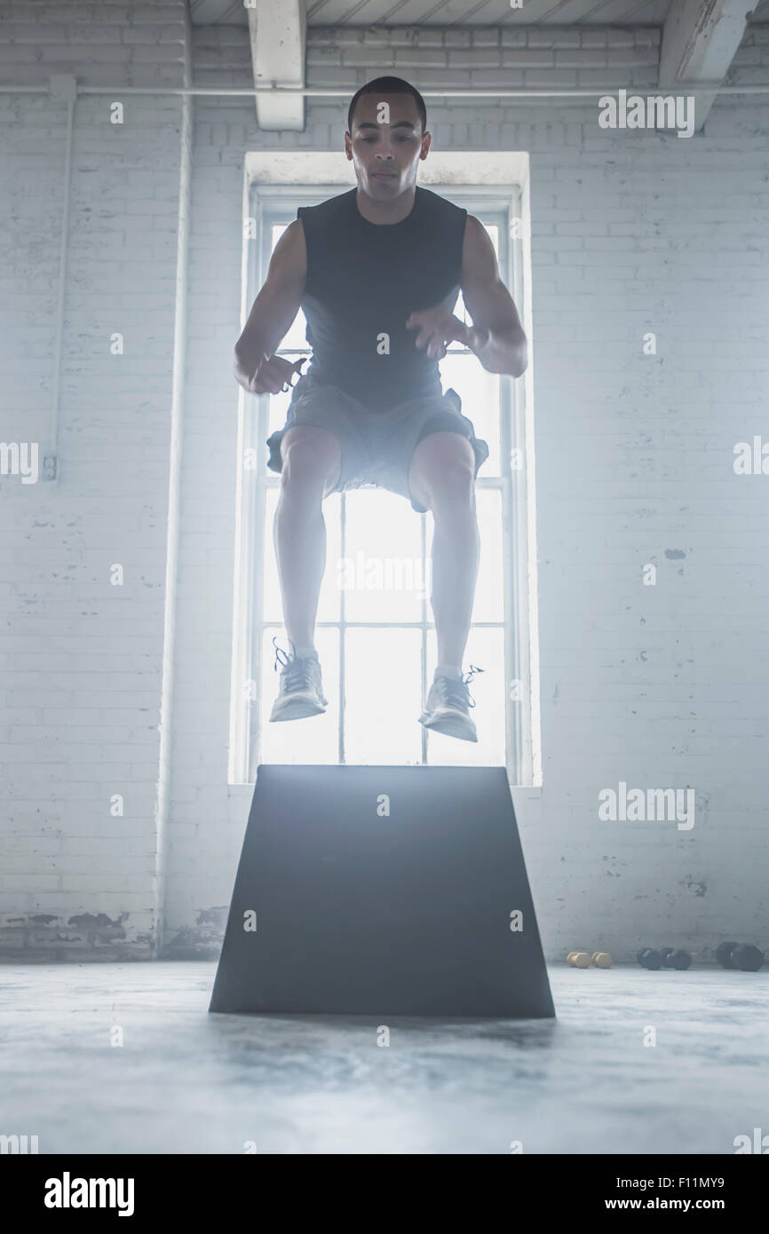 Athlete jumping on platform Stock Photo - Alamy