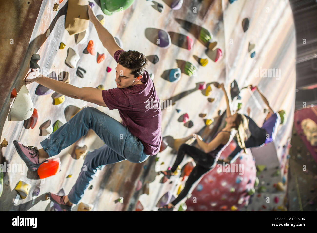 Athletes climbing rock wall in gym Stock Photo - Alamy