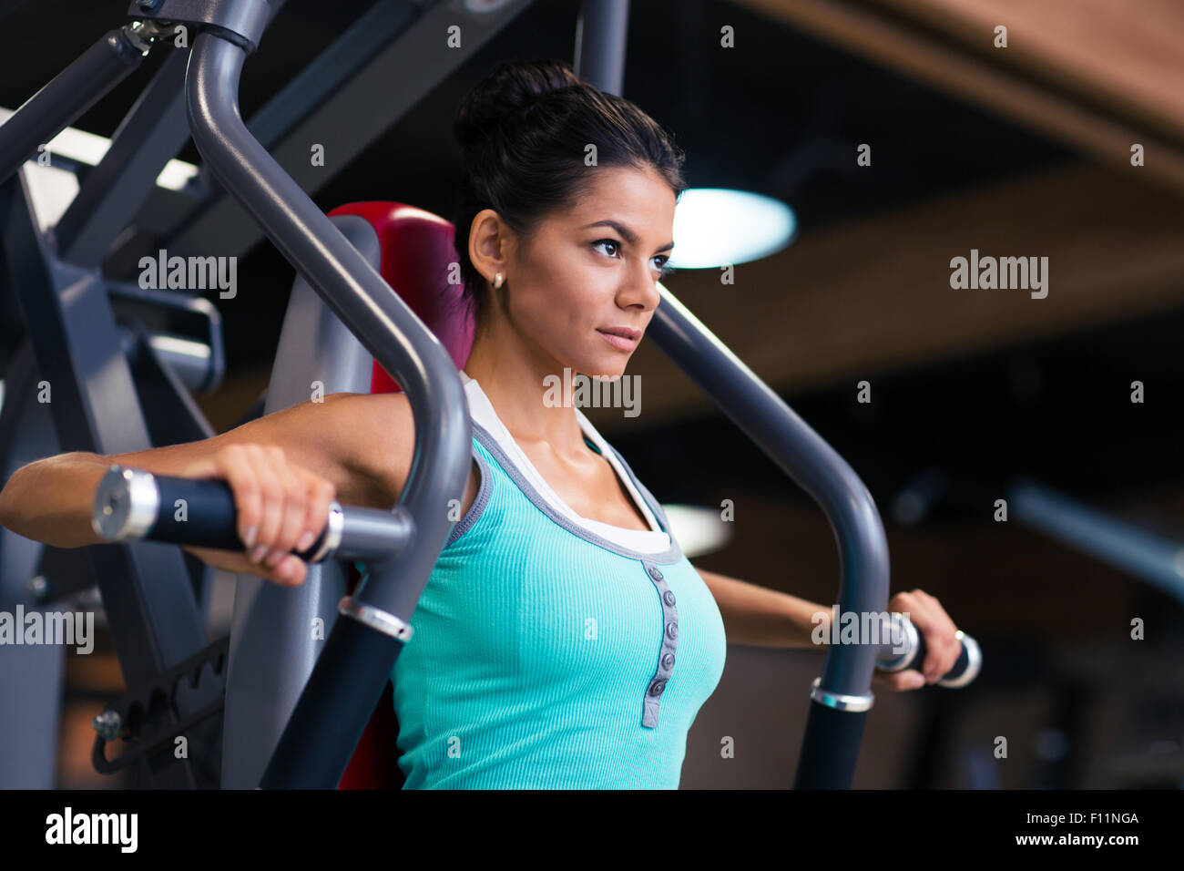 Portrait of a sports woman workout on exercises machine at fitness gym ...