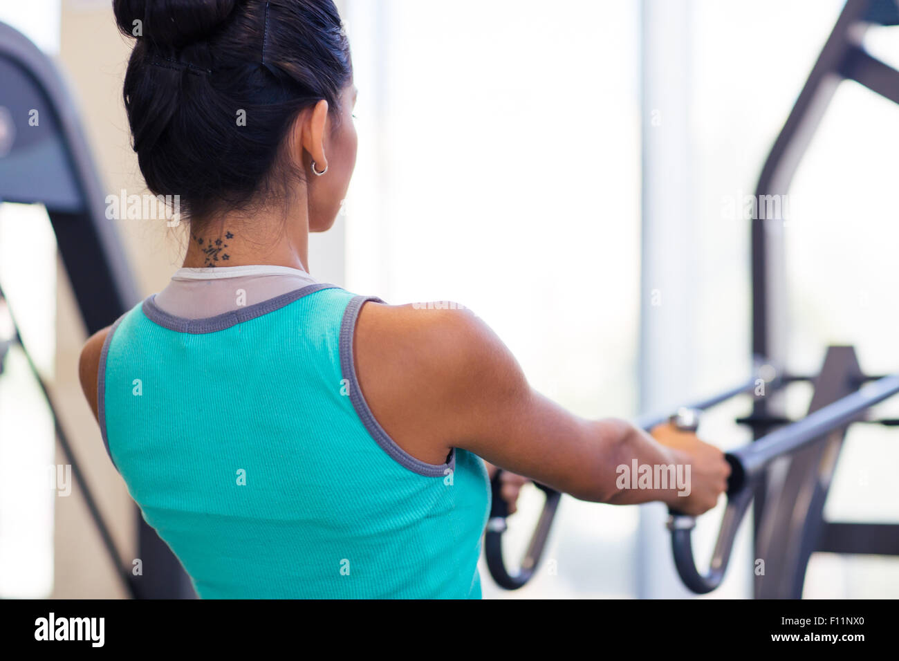 Back view portrait of a woman workout on exercises machine in fitness ...