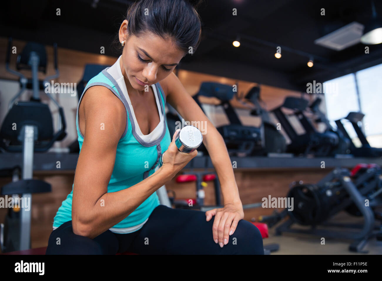 Young girl workout with dumbbell on the bench in gym Stock Photo - Alamy