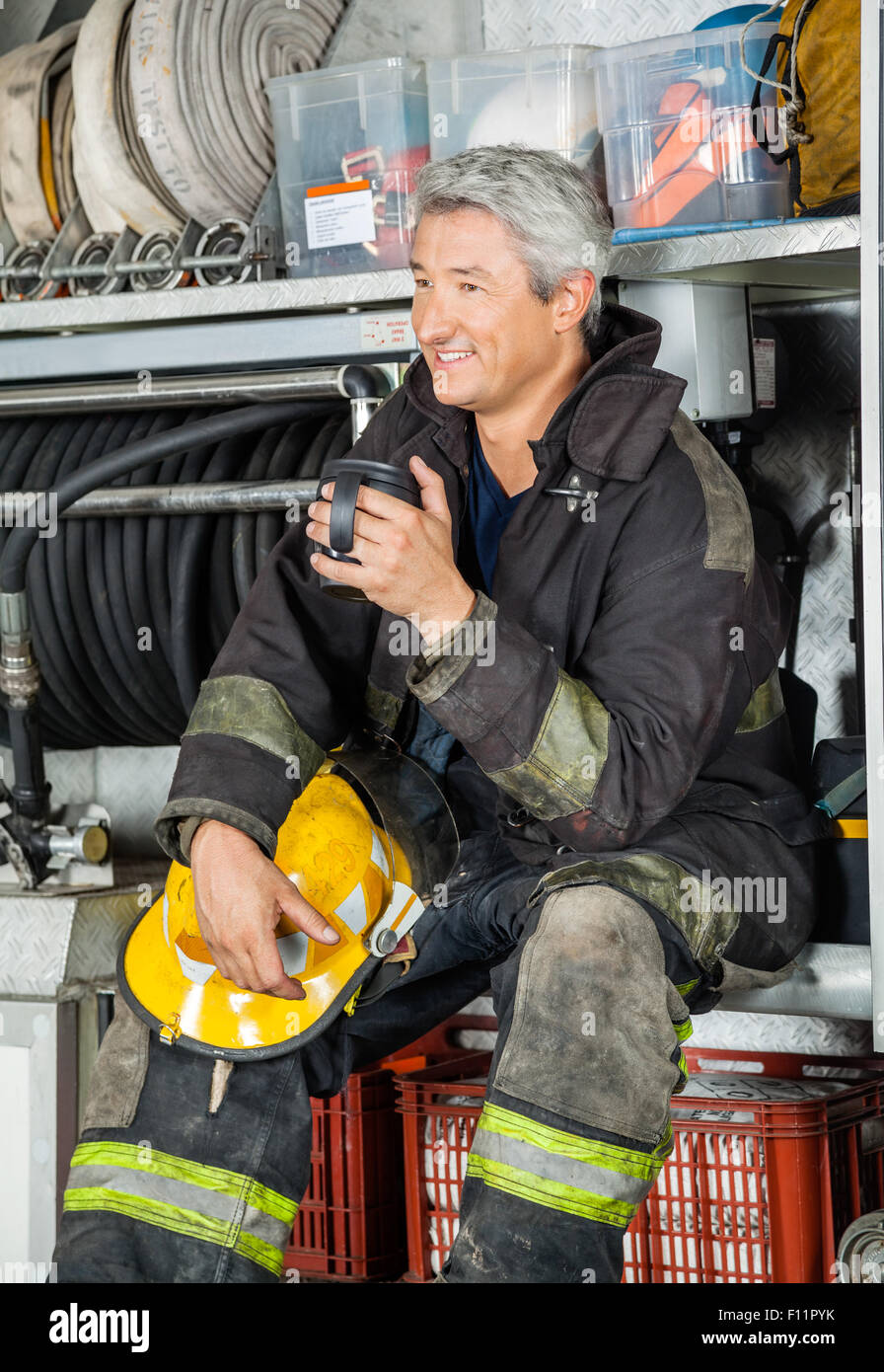 Smiling Fireman Sitting In Truck At Fire Station Stock Photo - Alamy