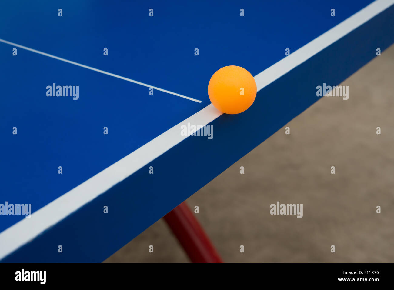 pingpong ball hits the edge of a blue pingpong table Stock Photo - Alamy