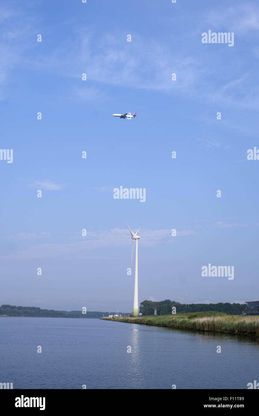 Airplane flying over wind Turbine Stock Photo - Alamy