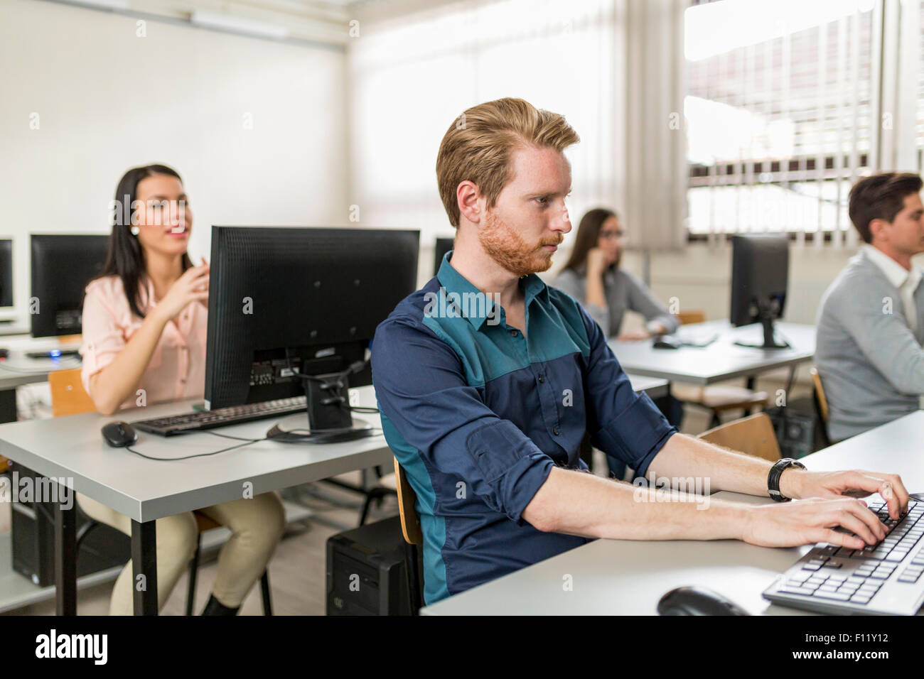 Young handsome student using computer in classroom Stock Photo - Alamy