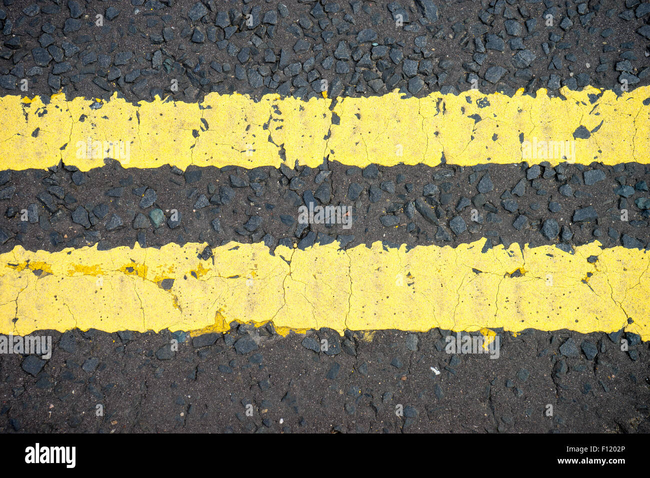 Double yellow lines on a tarmac road Stock Photo - Alamy