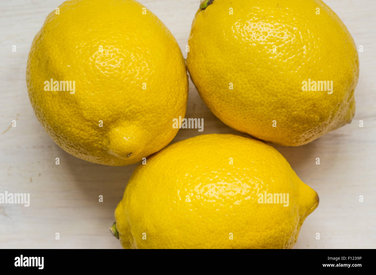Three ripe lemons on the table top view Stock Photo - Alamy