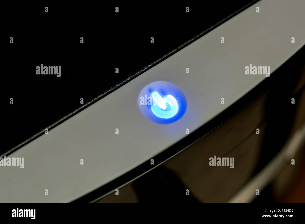Blue illuminated Power button on top of a personal computer Stock Photo ...