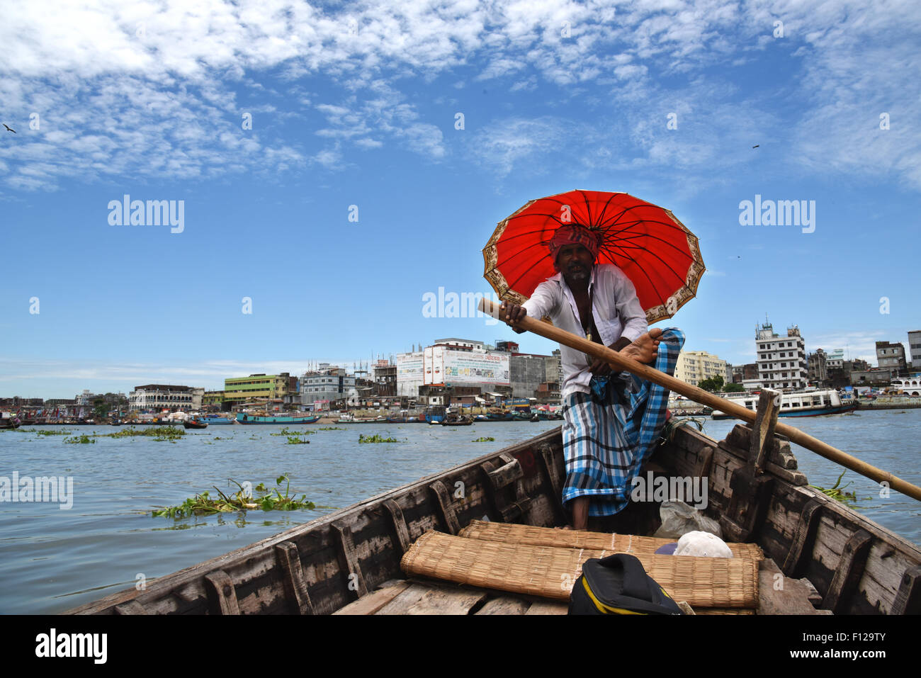 A boat man driving his boat on the Buriganga River in Dhaka, Bangladesh ...