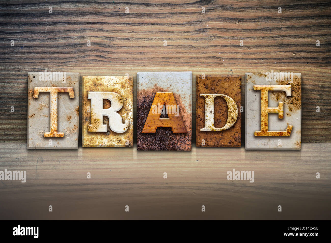 The word "TRADE" written in rusty metal letterpress type sitting on a ...
