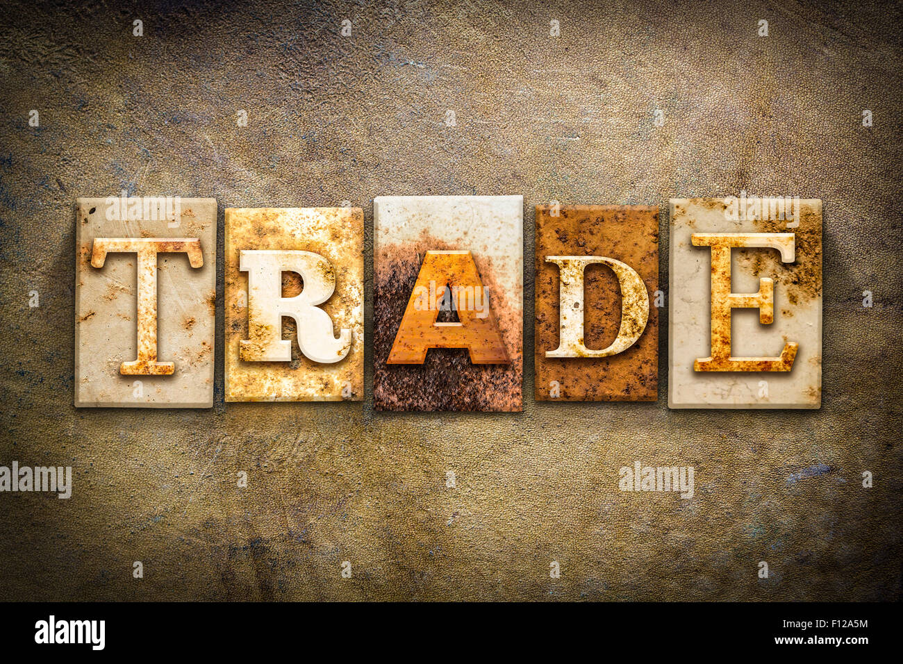 The word "TRADE" written in rusty metal letterpress type on an old aged ...