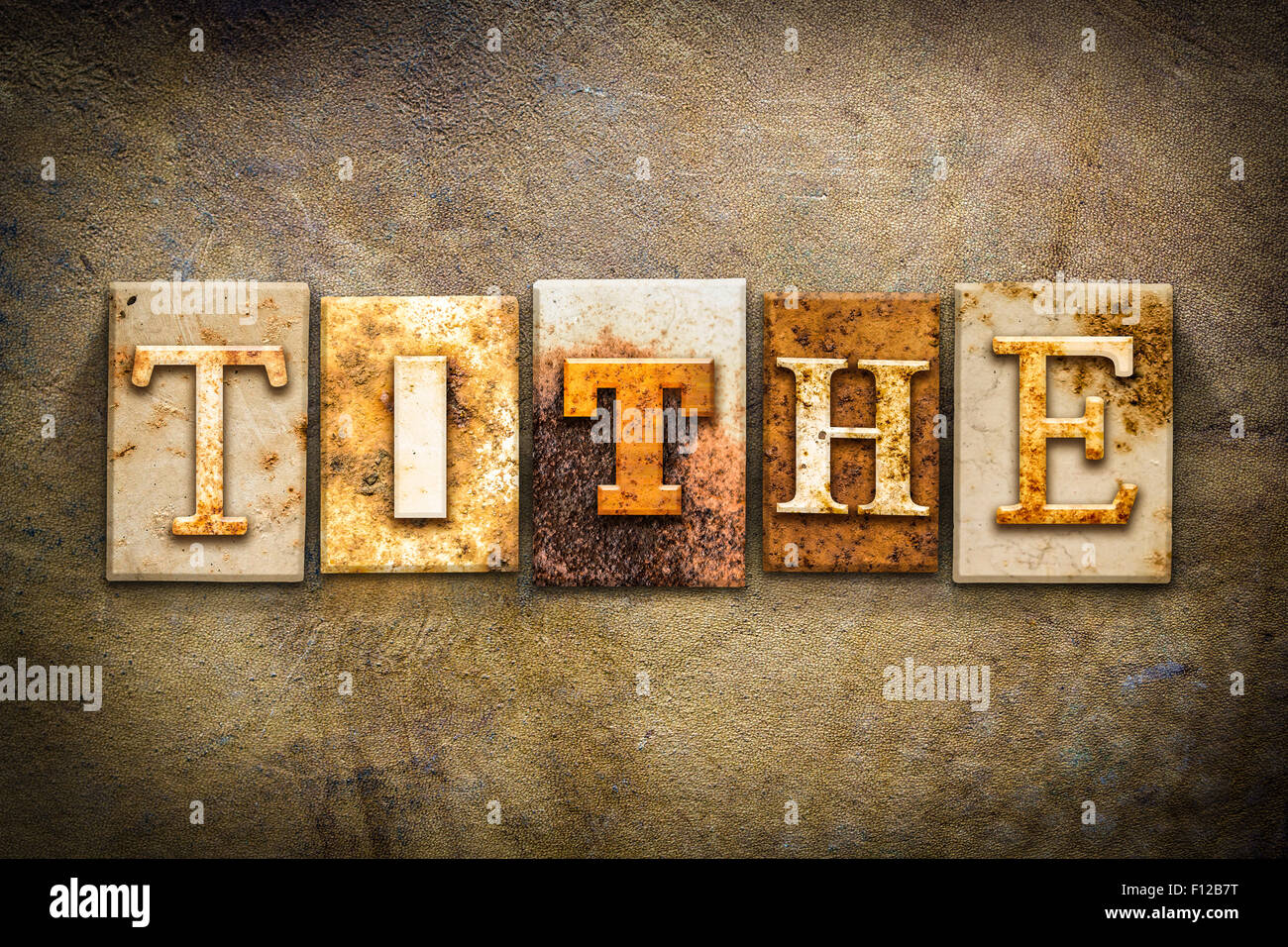 The word "TITHE" written in rusty metal letterpress type on an old aged ...