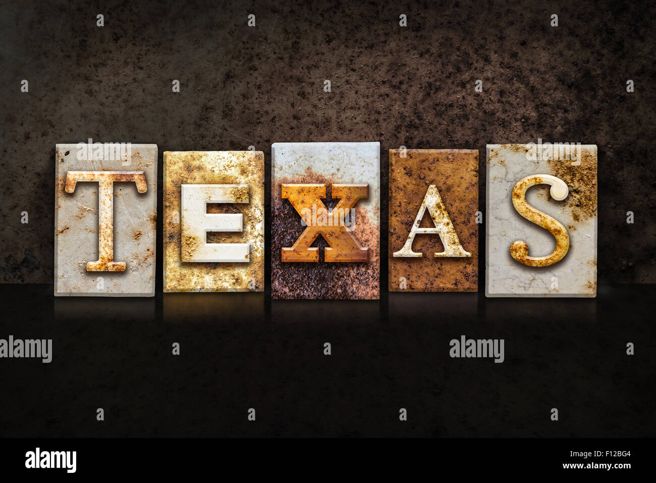 The word "TEXAS" written in rusty metal letterpress type on a dark ...