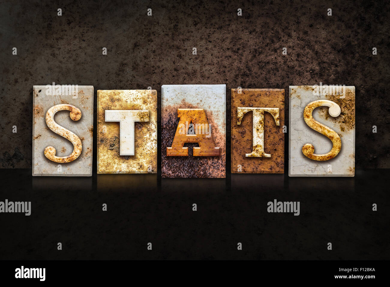 The word "STATS" written in rusty metal letterpress type on a dark ...