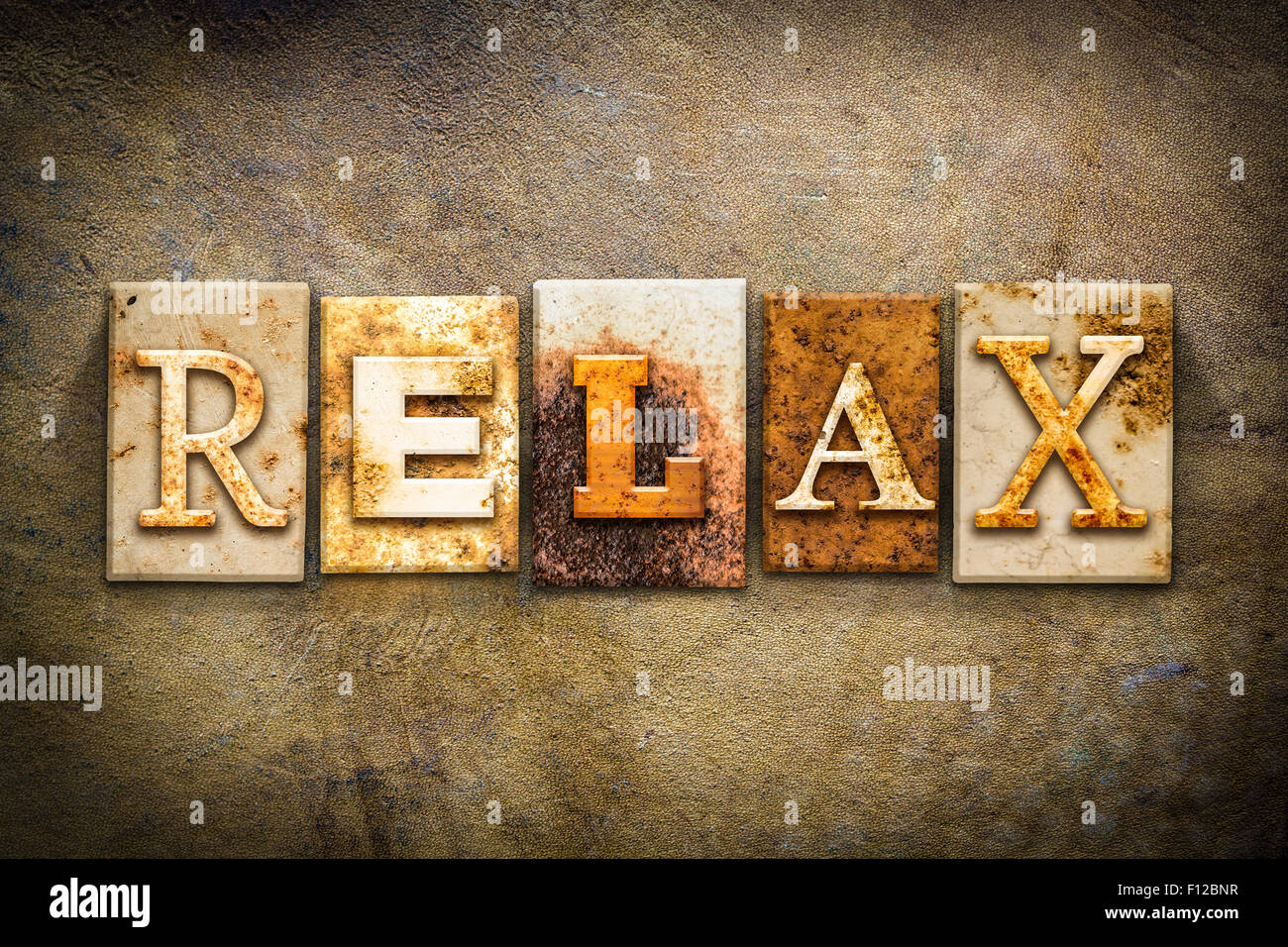 The word "RELAX" written in rusty metal letterpress type on an old aged ...